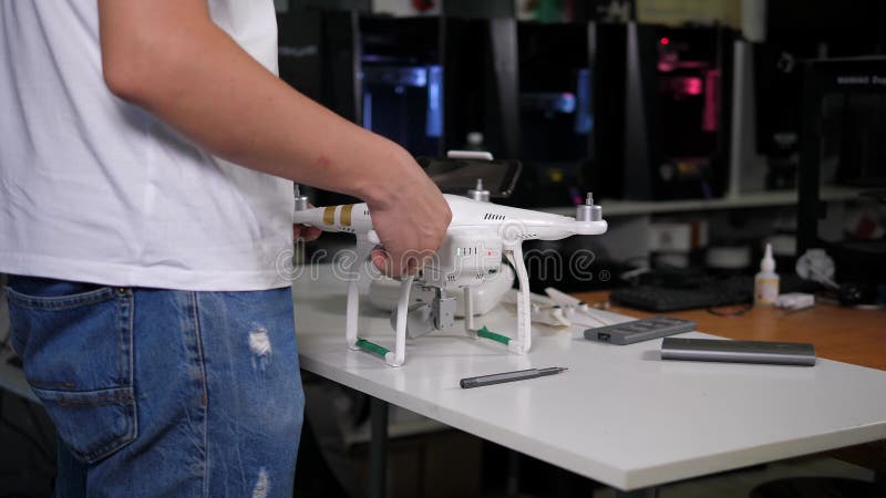 Close-up of a Man Assembling a Quadcopter in the Studio. a Man Repairs ...