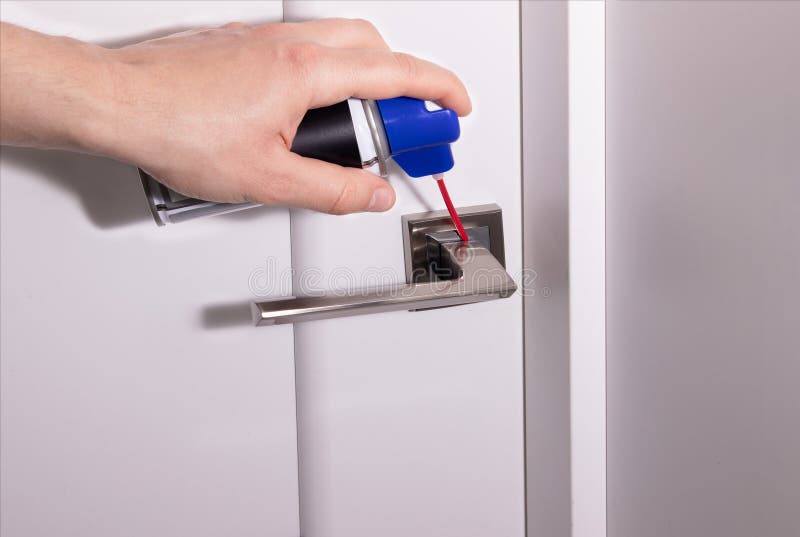 Close Up of Man Hand Lubricating Door Handle with Oil Spray. Prevent ...