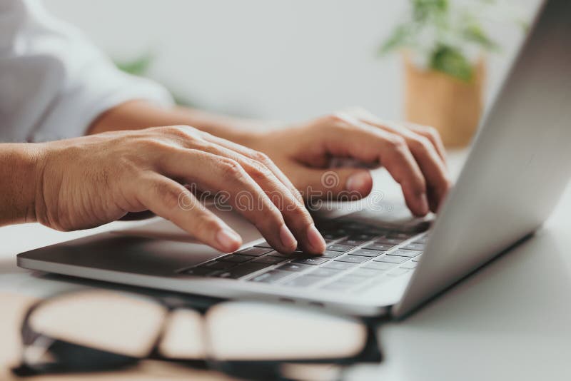 Close-up of Man Hands Typing on Laptop Keyboard on White Table at Home ...