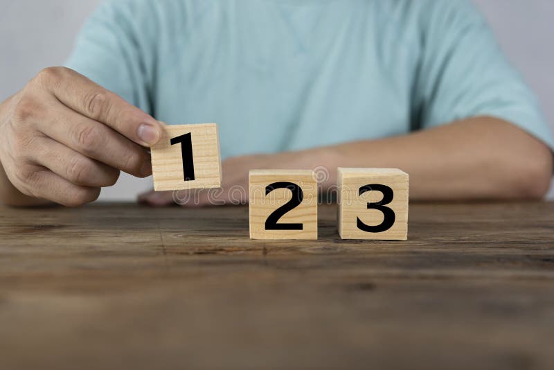 Close-up of a Man Holding a Wooden Block Numbered One, Two and Three on ...