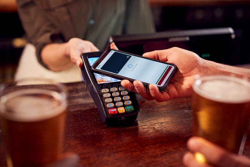 Close Up of Man Paying for Drinks at Bar Using Contactless App on ...