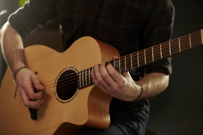 Close Up of Man Playing Acoustic Guitar in Studio Stock Image - Image ...