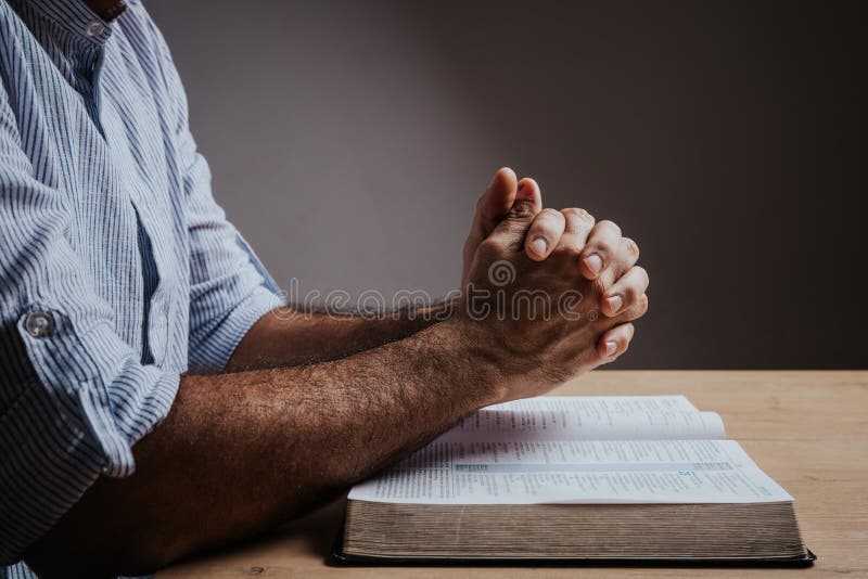 Man is Praying with His Hands Together Over the Open Bible, Side View ...