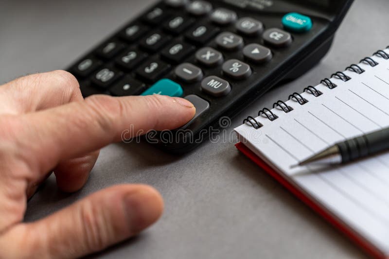 Close-up of a Man`s Hand Doing Calculations on a Calculator. the Index ...