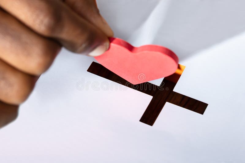 Man Inserting Heart Shape in Crucifix Slot Stock Photo - Image of ... Man Inserting Heart Shape in Crucifix Slot Stock Photo - Image of ...
