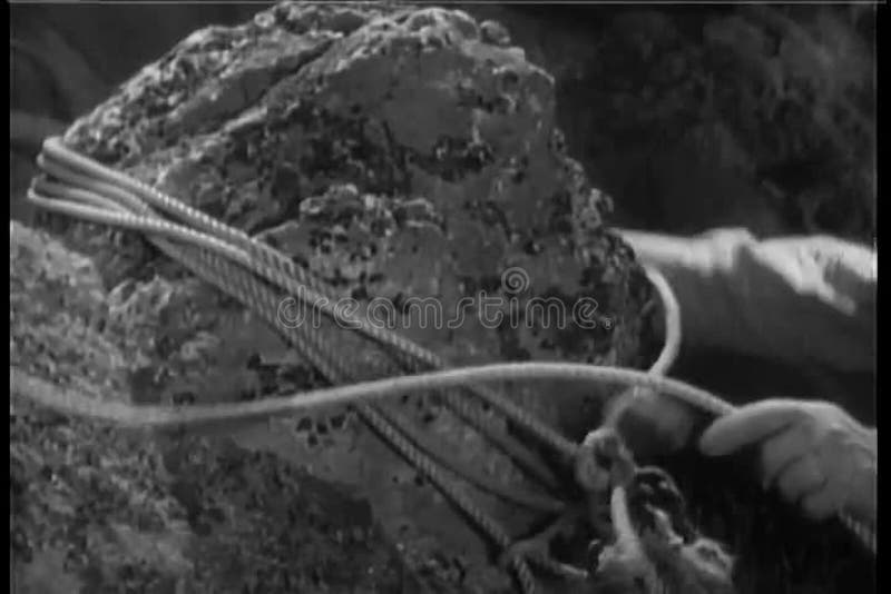 Close-up of Man Tying Rope Around Rock Stock Footage - Video of motion ...