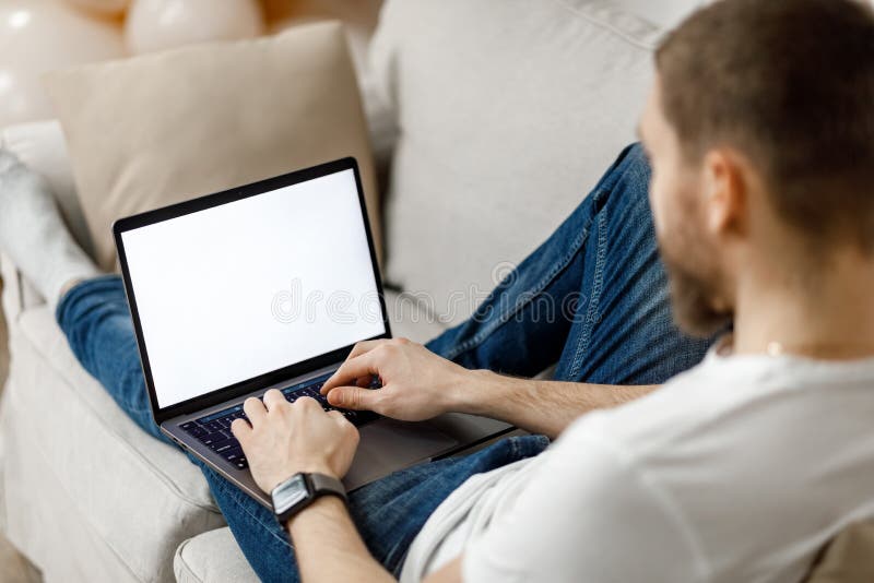 Close-up of a Man Working on a Laptop at Home on the Couch. No Face ...