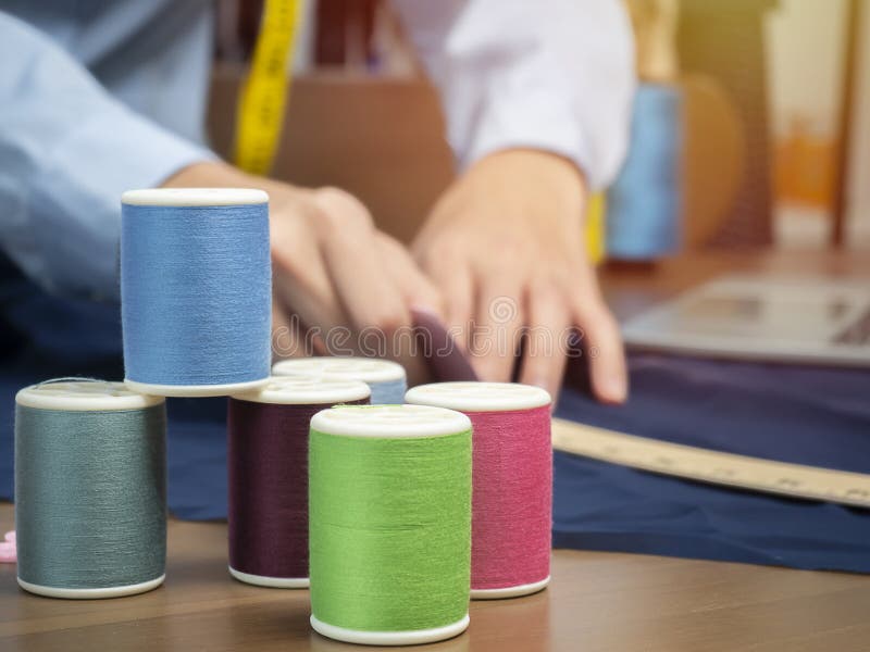 Close Up of Many Spool of Thread and Blurred Behind with Woman Tailor ...