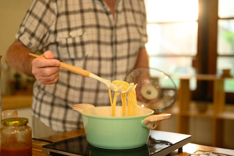 Close Up of Mature Man Preparing Spaghetti in a Cozy Kitchen Stock ...