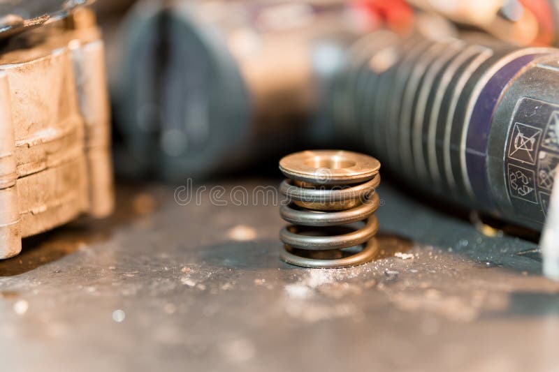 Close-Up of a Metal Compression Spring on a Workbench Surrounded by ...