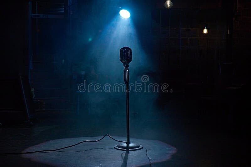 Closeup of a Microphone on a Dark Stage Illuminated by a Single ...