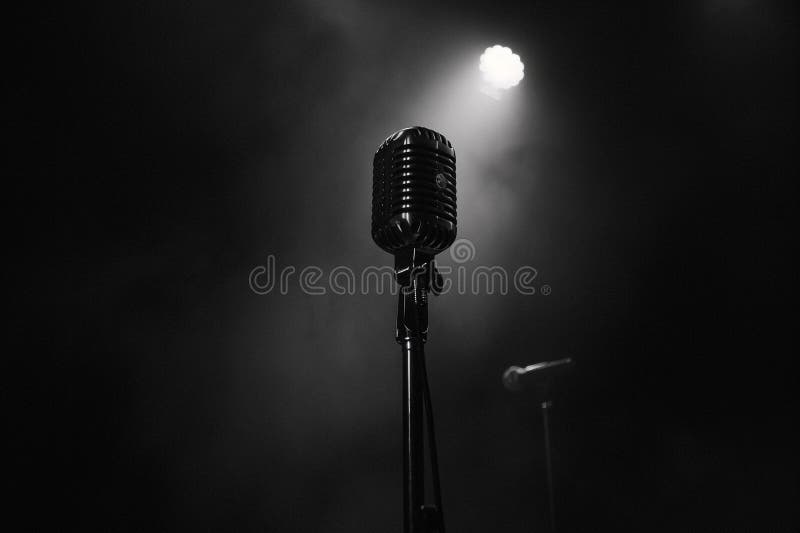 Closeup of a Microphone on a Dark Stage Illuminated by a Single ...