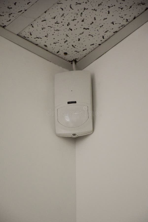Close-up Motion Sensor in the Corner of a Living Room or Office Under a ...