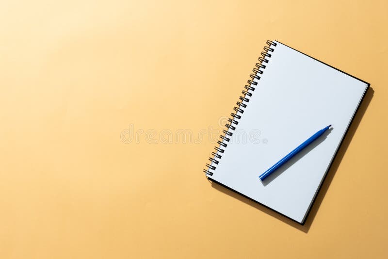 Close Up of Notebook and Blue Marker with Copy Space on Orange ...