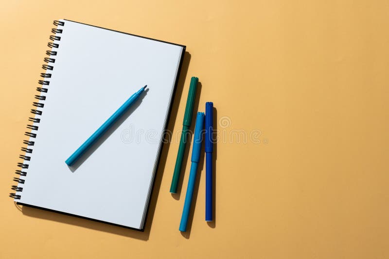 Close Up of Notebook and Four Markers with Copy Space on Orange ...