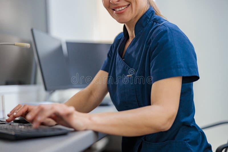 Close Up of Nurse on Duty Working on Computer at the Reception Desk in ...