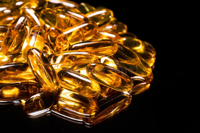Close Up of Omega 3 Gel Capsule on a Reflective Black Background Stock ...