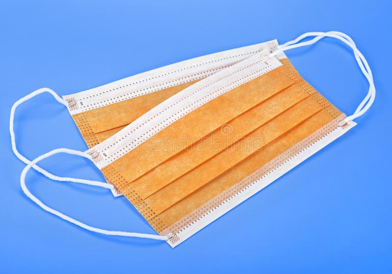 Close Up of Orange Disposable Face Mask on Blue Background. Protective ...