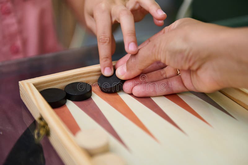 Close-up of a Parent and Child Playing a Game of Backgammon Together ...