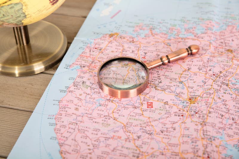 Close-up of a Part of the Globe and a Map and Magnifying Glass Spread ...