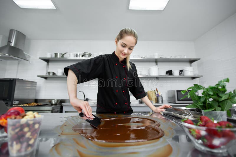 Close-up of a Pastry Chef Using Spatulas Tempering Molten Chocolate ...