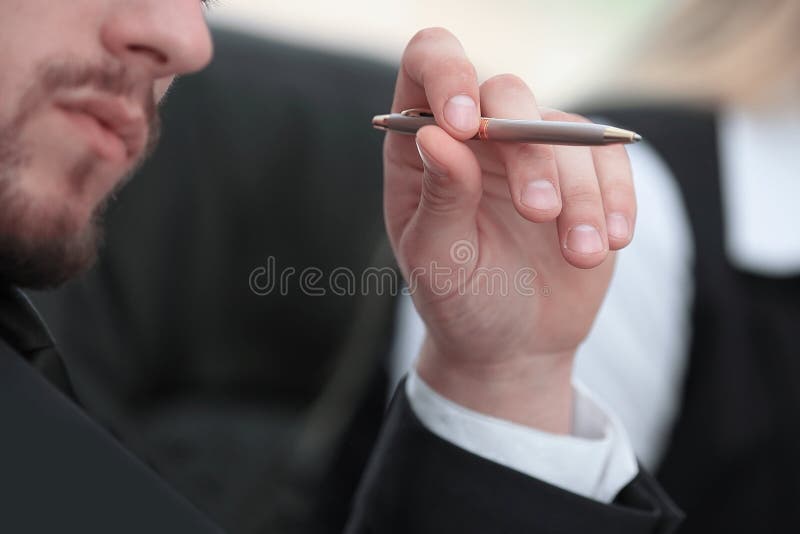 Close Up. Pensive Businessman with Pen Sitting at Table Stock Photo ...