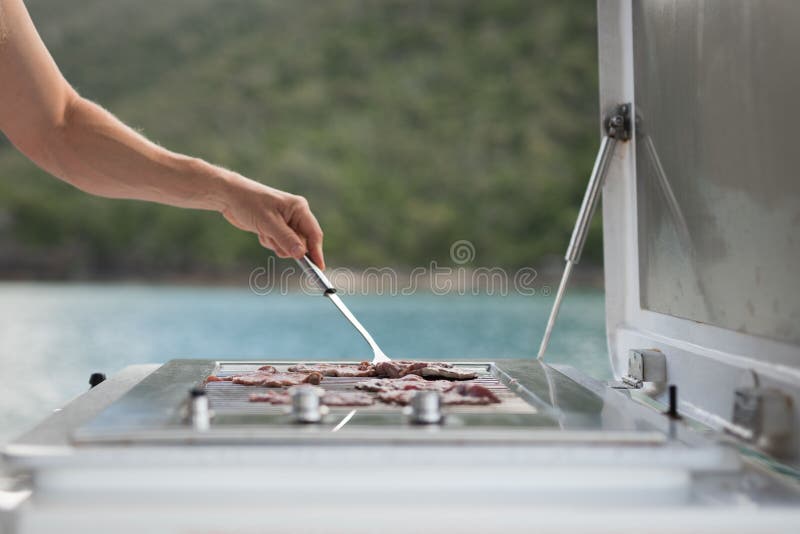 Close-up of a Person Cooking Bacon on a Grill Outside in Front of the ...