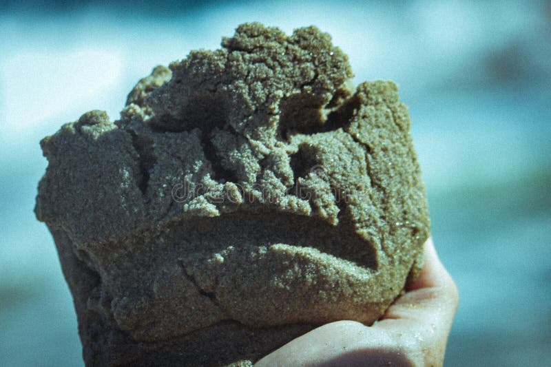 A Close Up of a Person Holding an Object in the Sand Stock Photo ...