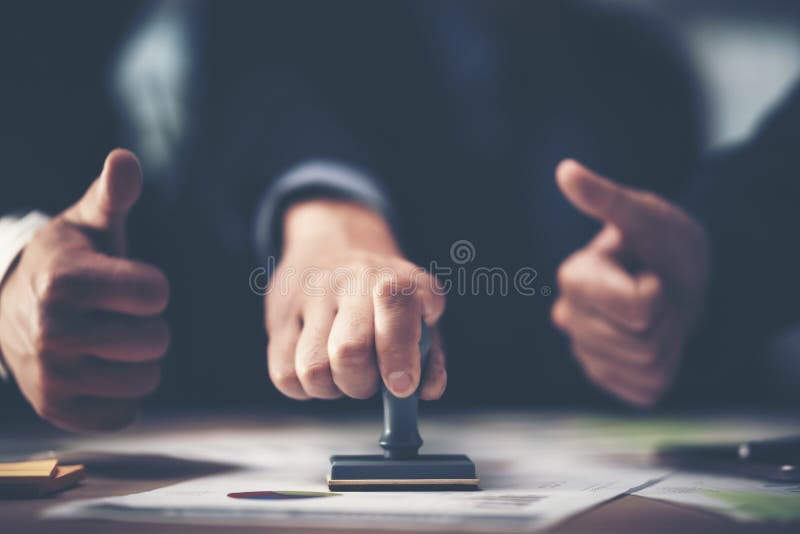 Close-up of a Person`s Hand Stamping with Approved Stamp on Document at ...