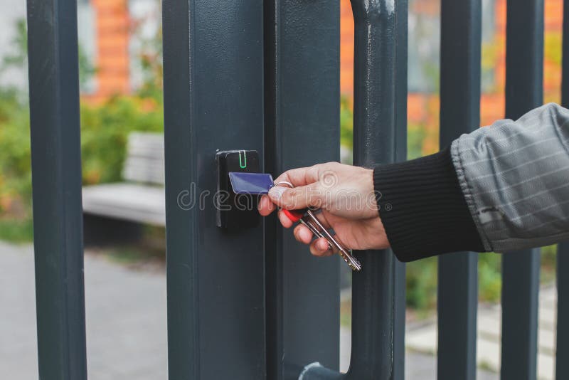 Close Up of Person Using Key Card To Open Metal Gate of Residential Complex, Symbolizing ...