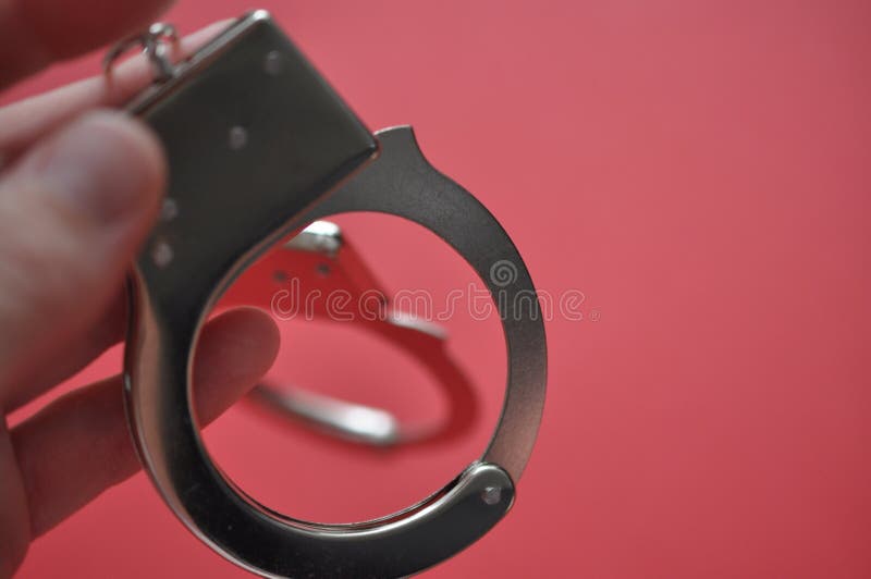 Handcuffs in hand stock image. Image of hand, gadget - 337616491