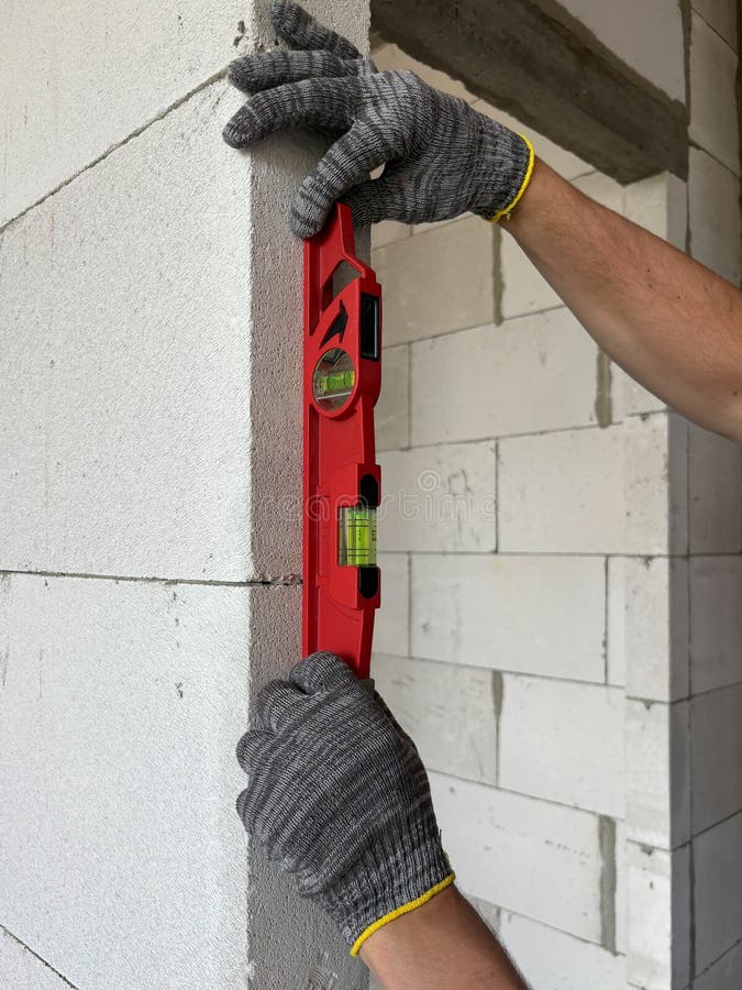 A Close-up Photo of a Level in the Hands of a Builder Measuring the ...