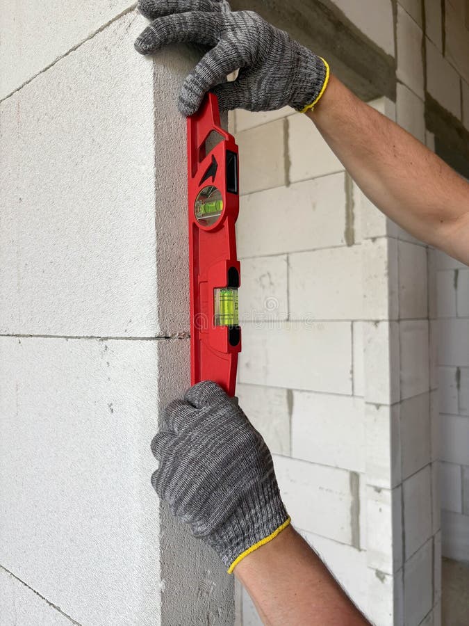 A Close-up Photo of a Level in the Hands of a Builder Measuring the ...
