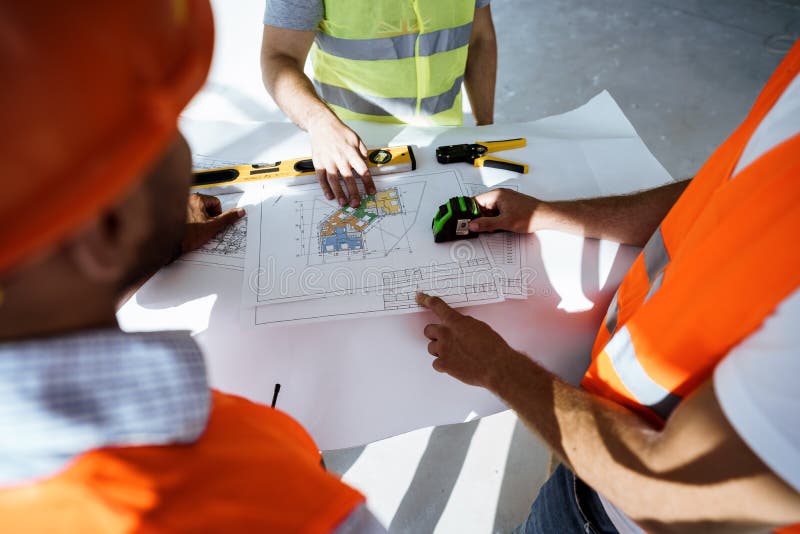 Close Up of Three Man Engineers Looking at Blueprint on Construction ...