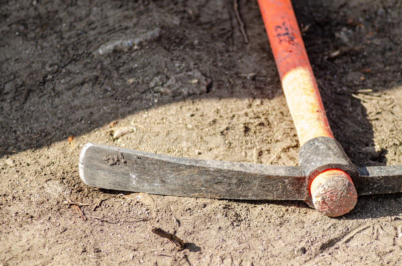 Close-up of a Pickaxe Lying on the Ground at a Work Site, Featuring a ...