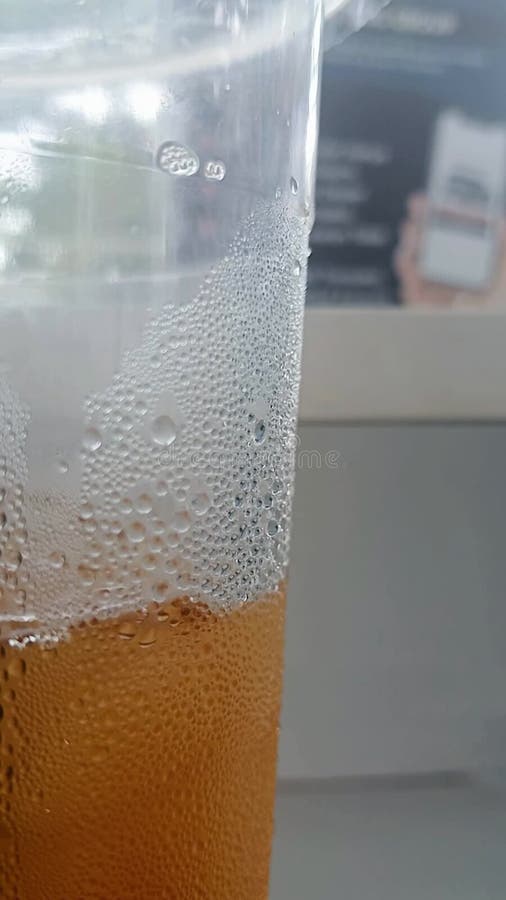 Close-up of a Plastic Cup Filled with Iced Tea, Featuring Condensation ...