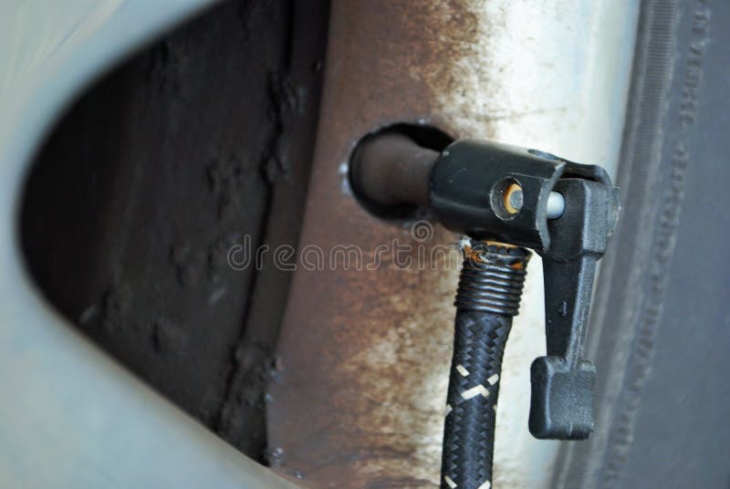 Close Up of a Portable Air Compressor Connected To the Valve Stem of a ... Close Up of a Portable Air Compressor Connected To the Valve Stem of a ...
