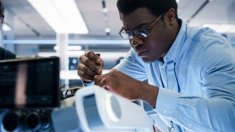 Close Up Portrait of an African American Robotics Engineer Setting Up a ...
