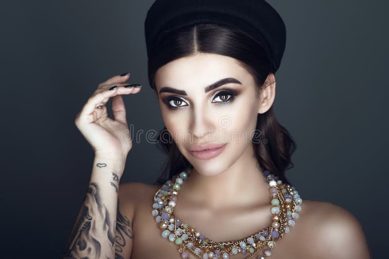 Glam Dark Haired Tattooed Model With Beautiful Make Up And Smooth Hair