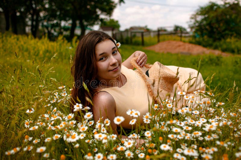 Portrait Of Lovely Young Romantic Woman Lies In Chamomile Flower Field