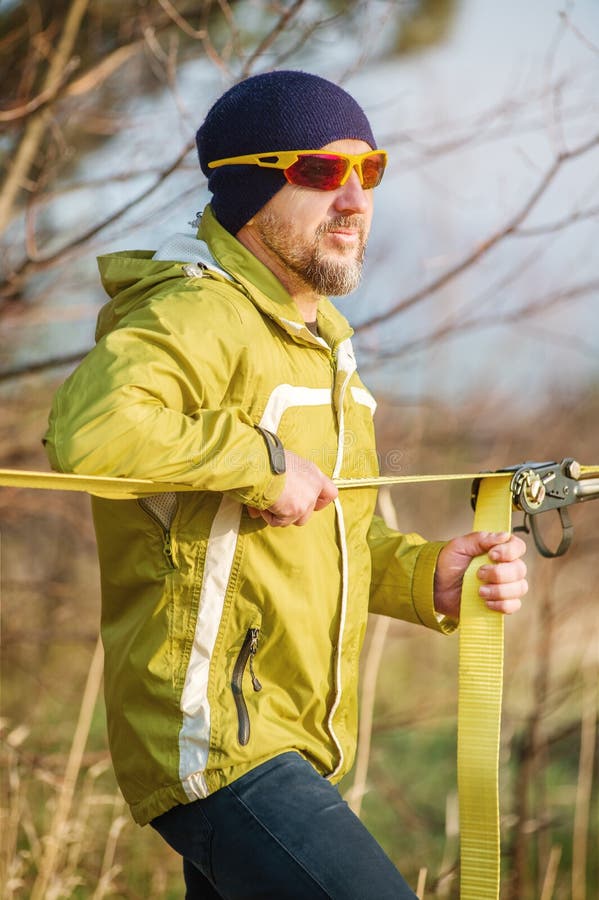 Close-up Portrait of a Man Adjusting Slacklining Equipment before ...