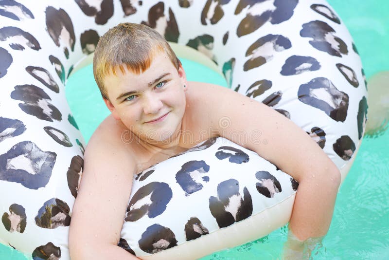 Close Up Portrait of Pre-teen Boy Floating on Leopard Print Inflatable ... Close Up Portrait of Pre-teen Boy Floating on Leopard Print Inflatable ...
