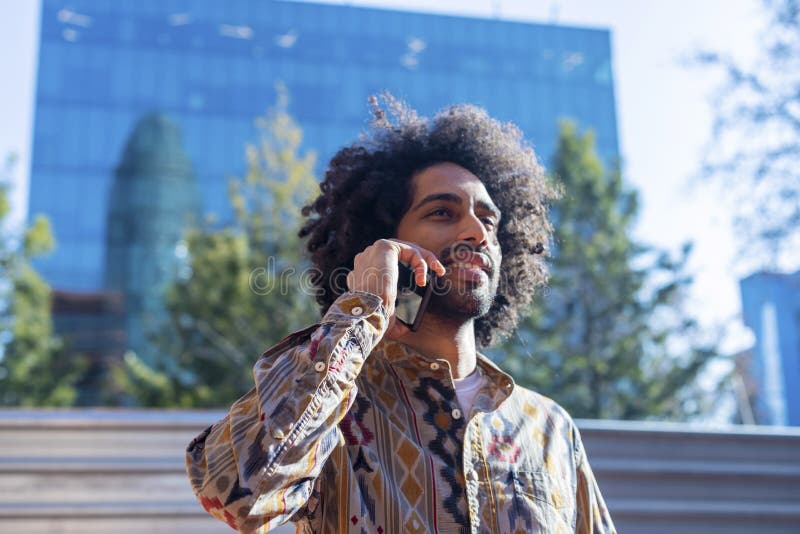 Front View of a Handsome Smiling Afro Man Using a Mobile Phone while ...