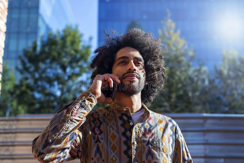 Front View of a Handsome Smiling Afro Man Using a Mobile Phone while ...