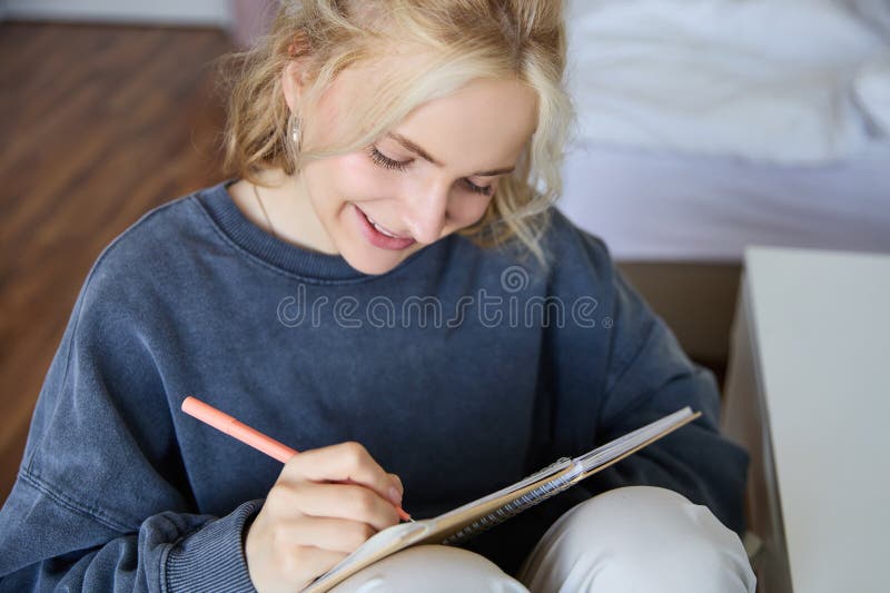 Close Up Portrait of Smiling Girl, Writing in Notebook, Adds Notes To ...
