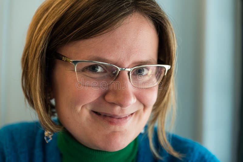 Close Up Portrait Of A Smiling 30 Year Old White Woman Indoors Stock