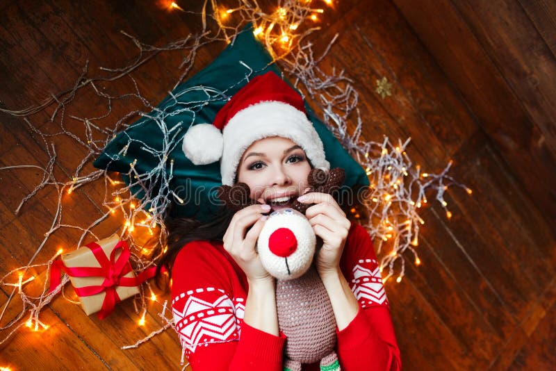 Close Up Portrait Of Woman In Santa Hat Wrapped In Christmas Lights