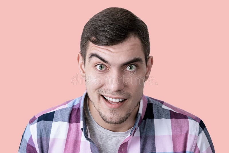 Close-up Portrait of a Young Guy with a Naughty Face Looking at the ... Close-up Portrait of a Young Guy with a Naughty Face Looking at the ...