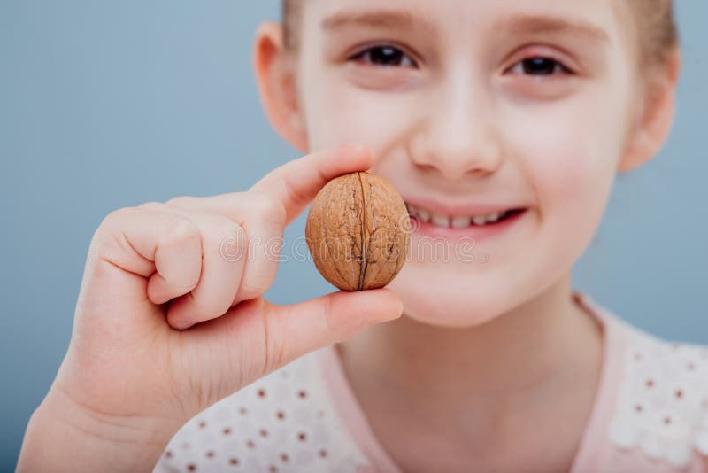 Close Up, Portret of Child with Walnut in Hand on Blue Stock Photo ...