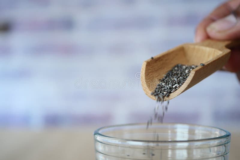 Close Up of Pouring Chia Seeds in a Glass of Water Stock Photo - Image ...